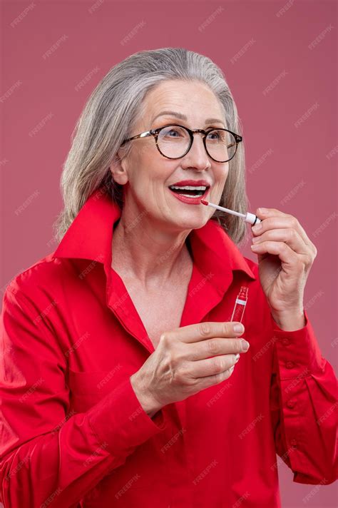 Premium Photo Good Looking Mid Aged Woman Putting Lip Gloss On Her Lips