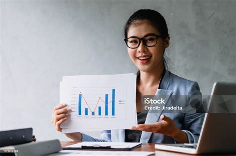 Longhaired Asian Business Woman Showing A Graph Charts To Present About