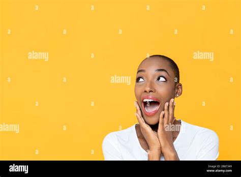 Shocked African American Woman With Hands On Cheeks Gasping And Looking
