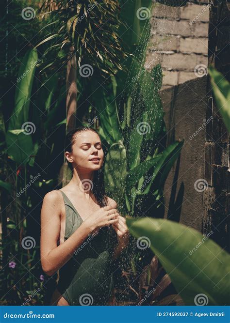Woman Body In A Swimsuit Takes A Tropical Shower Outdoors Against The