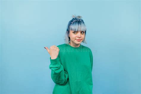 Upset Hipster Girl In Casual Clothes With Colored Hair Stands On A Blue