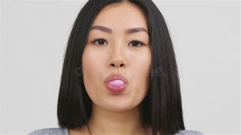 Korean Lady Chewing And Blowing Bubblegum White Background Side View