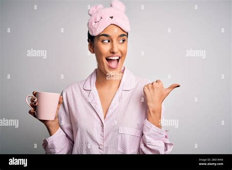 Young Beautiful Brunette Woman Wearing Pajama And Sleep Mask Drinking
