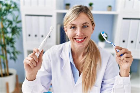 Beautiful Dentist Woman Holding Ordinary Toothbrush And Electric