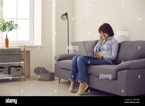Woman Tired Of Working On Laptop Computer Takes Off Her Glasses And