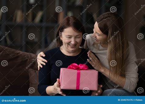 Loving Grown Up Daughter Congratulating Mature Mother Presenting T