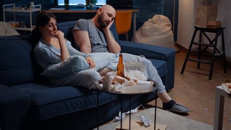Frustrated Young Couple Sitting In Couch Feeling Disappointed Stock