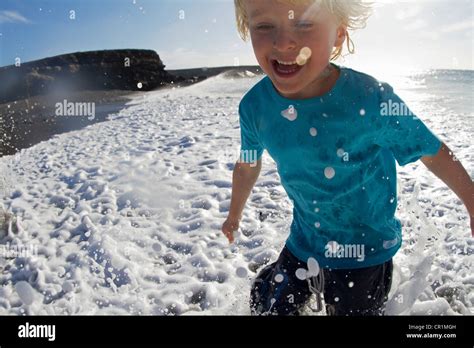 Enfants Jouant Des Vagues De La Plage Banque De Photographies Et D