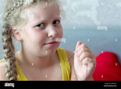 Girl Holds Thread To Pull Out A Milk Tooth Removal Of Tooth At The