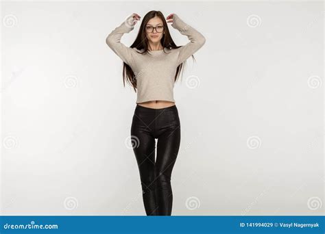 Beautiful Brunette Young Woman In Glasses And Black Leggings Stretching