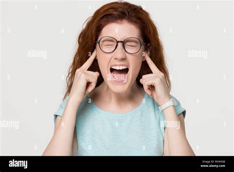 Stubborn Angry Redhead Girl Sticking Plug Fingers In Ears Screaming