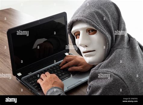 Thief Hacker In Mask Stealing Personal Information From Laptop Concept