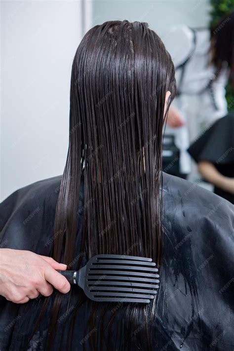 Premium Photo Hairdresser Applies A Hair Mask To Straight Black Hair