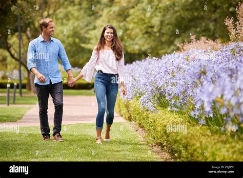 Couple Walking Hand In Hand In The Park