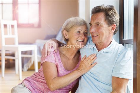 Loving Senior Couple Embracing In Their Living Room Royalty Free Stock