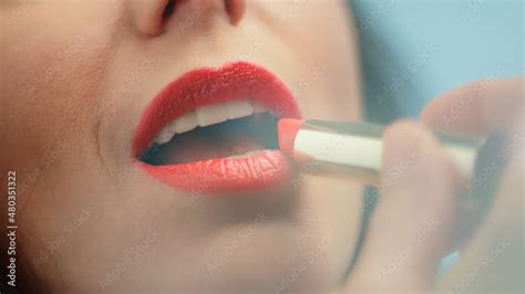 Beautiful Woman Applies Red Lipstick To Her Sensuous Full Lips
