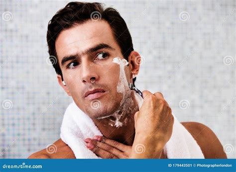 Portrait Of Young Attractive Man Applying Beard Foam And Shaving His