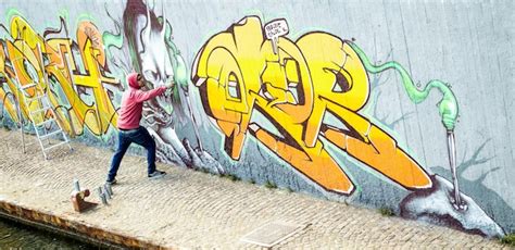 Amplia Vista Del Artista Callejero Pintando Graffitis Coloridos En Una