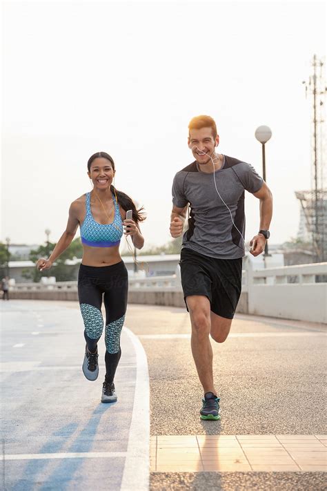 Couple Running Together In The City By Stocksy Contributor Jovo