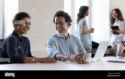 Happy Cheerful Diverse Coworkers Chatting At Workplace Laughing Stock