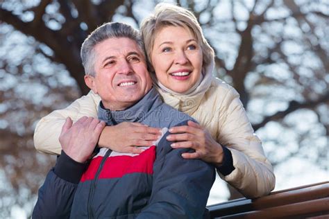 Positive Mature Married Couple Sitting On Park Bench Stock Image