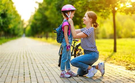 Une Joyeuse Mère De Famille Enseigne à Sa Fille à Faire Du Vélo Dans Le