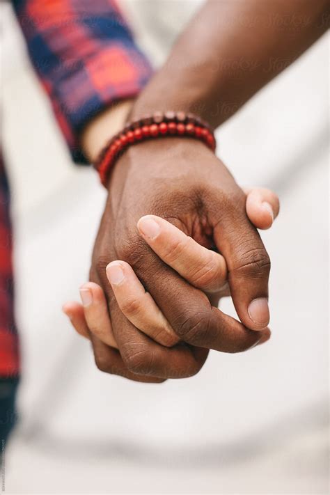 «multi Ethnic Couple Holding Hands Del Colaborador De Stocksy