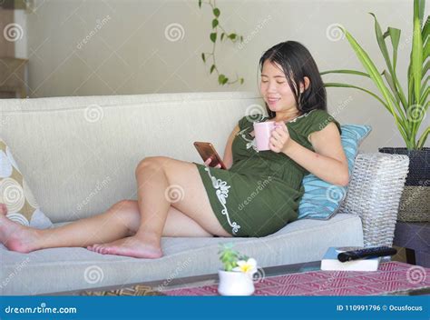 Young Beautiful And Relaxed Asian Chinese Woman Lying At Home Living