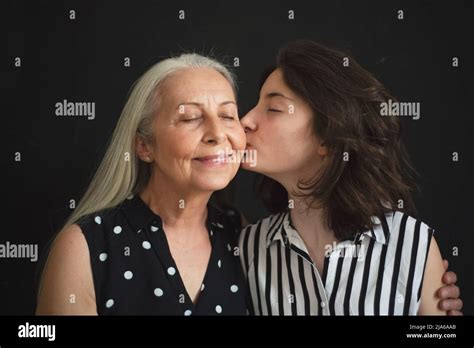 Portrait Of Senior Grandmother With Her Granddaughter Kissing Her Over