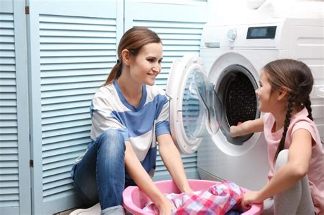 Premium Photo Mother And Daughter Loading Clothes Into Washing Machine