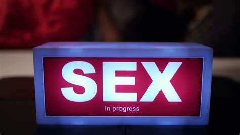 woman approaching man in bed sex sign in foreground stock footage video