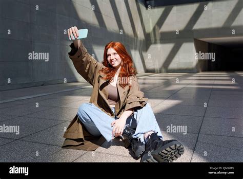 Happy Redhead Teen Girl Taking Selfie On Phone On Urban City Walls
