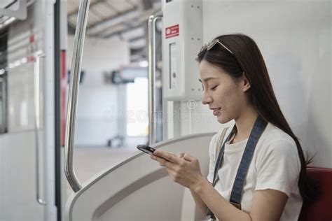 Asian Female Tourist Chatting Mobile Phone Travel By Thailand Train