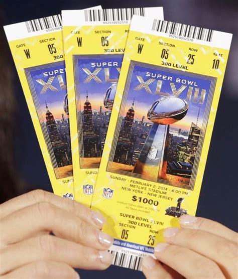 A Woman Holding Three Super Bowl Tickets In Front Of Her Face