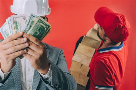 The Boss Pays Money To His Employee With Dollars In Hand Concept On A