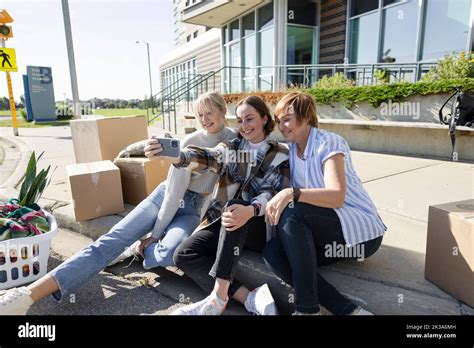 Mother And College Daughters Taking Selfie Outside Dormitory Stock