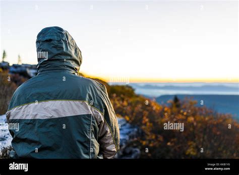 Standing Young Man In Green Coat Jacket With Hood On Windy Cold Autumn