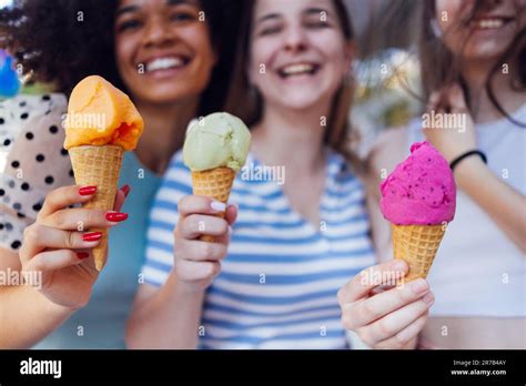 Three Cheerful Multiracial Female Teenager Girls Holding Colorful Ice