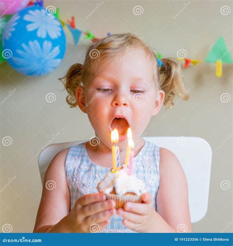 Blonde Caucasian Girl Blows Out Candles On A Festive Cake Concept Of