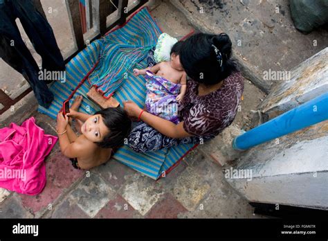 A Woman Living In Poverty Tends To Her Newborn As Her Older Sister