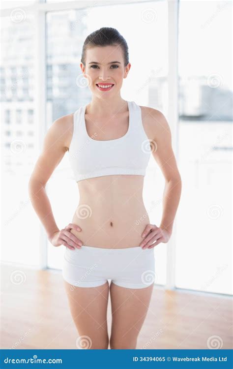 Pleased Fit Brown Haired Model In Sportswear Posing With Hands On The
