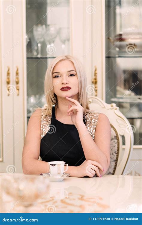Stylish Elegant Blonde Woman In Beauty Rich Interior Wearing Black
