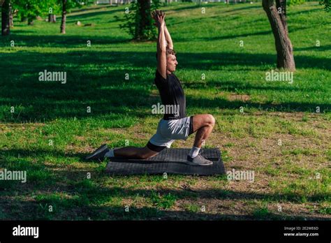 Sporty Young Man Stretching Legs And Doing Forward Lunge While Having