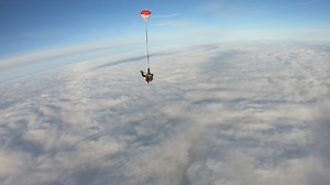 Skydiving. Tandem jump. Agirl is flyign in the winter sky.