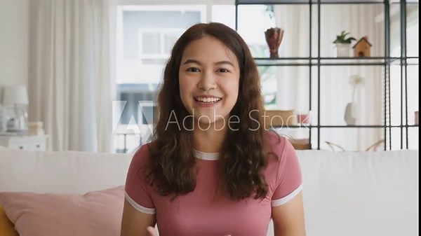 Device screen social media live talk look at camera chat app Gen Z asian. Young adult woman asia people teen happy smile advice work at home sit sofa selfie viral video call webcam online class tutor.