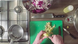 Time lapse, top view. Chef's hands peeling and cutting a ginger root on the chopping board