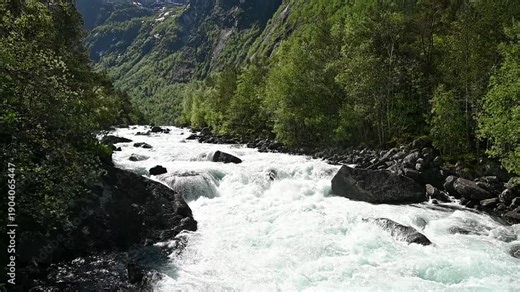 Kinso river flows in slow motion from Hardangervidden as camera lifts to reveal Husedalen valley in spring Norway
