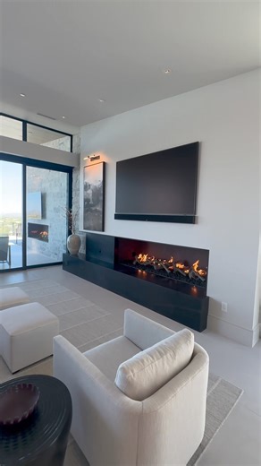 One of the most beautiful details at the great room of our #ModernSunset project is the linear fireplace. And when the multi-slider is open, there is a matching one on the exterior. | AFT Construction