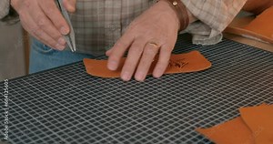 Leather marking process. focus on hands holding Wing Divider, leather Compass, necessary tools for sewing leather products Slow motion. craftsman concentrated on working with compass