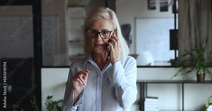 Mature businesswoman make call, having formal conversation to client by cellphone, standing at workplace, solve business remotely by phonecall, provide information, helps distantly. Mobile connection
